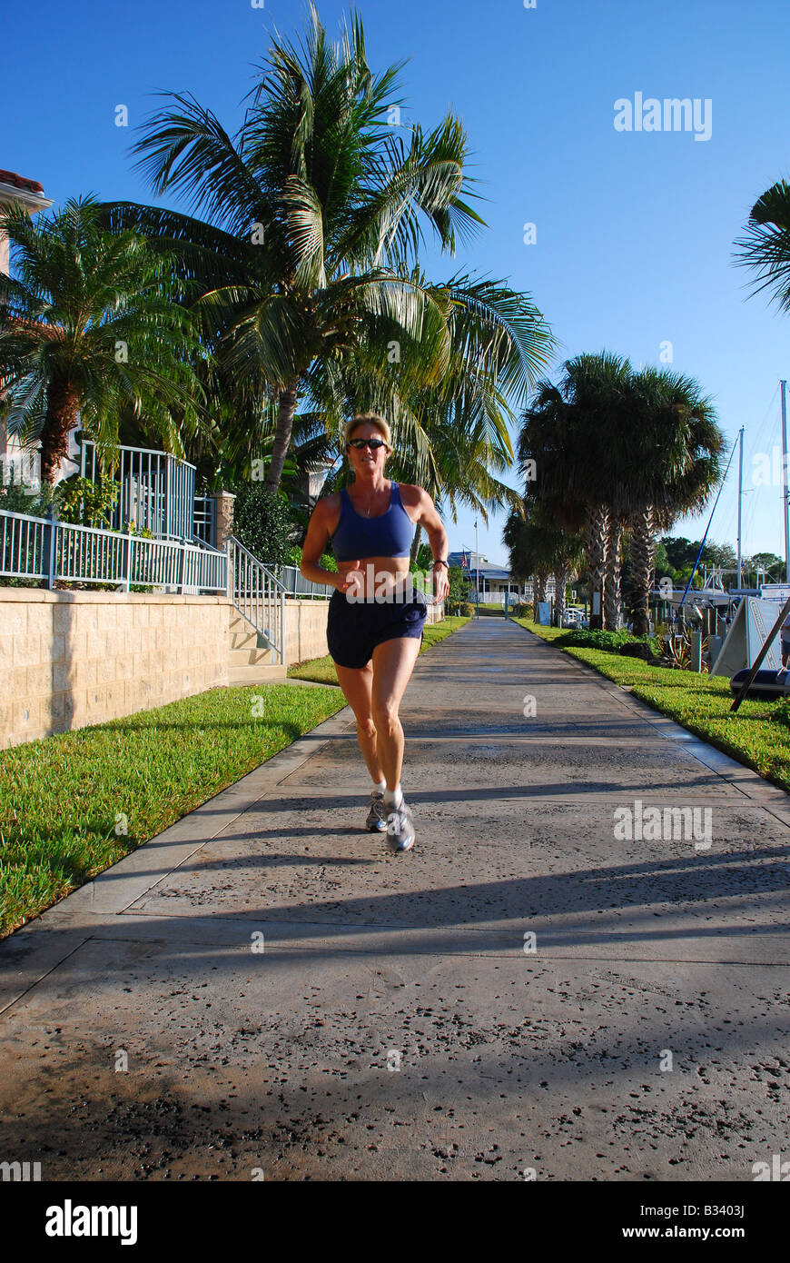 Woman running around marina Stock Photo - Alamy