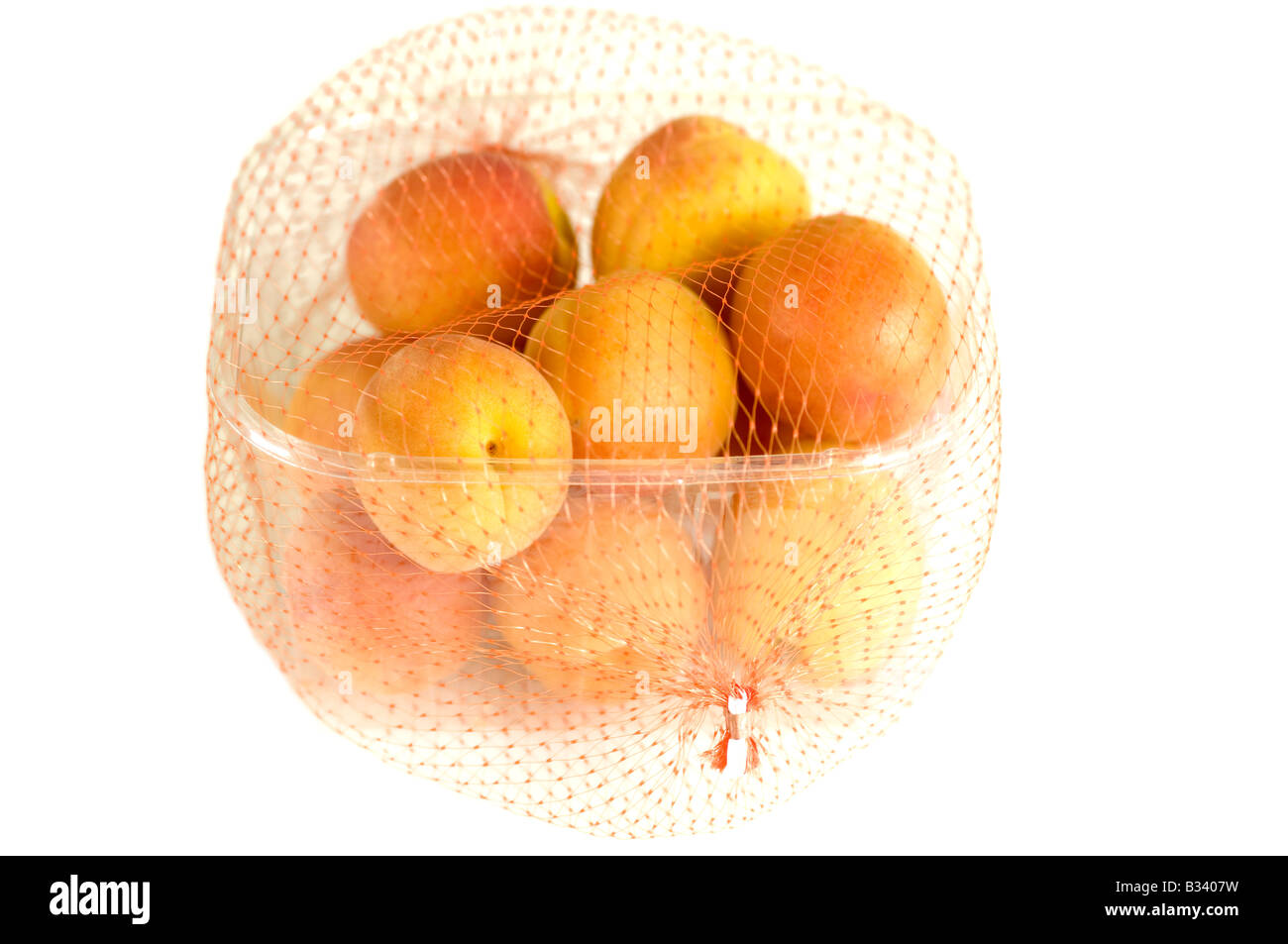 Apricots in a plastic punnet with orange mesh cover Stock Photo - Alamy