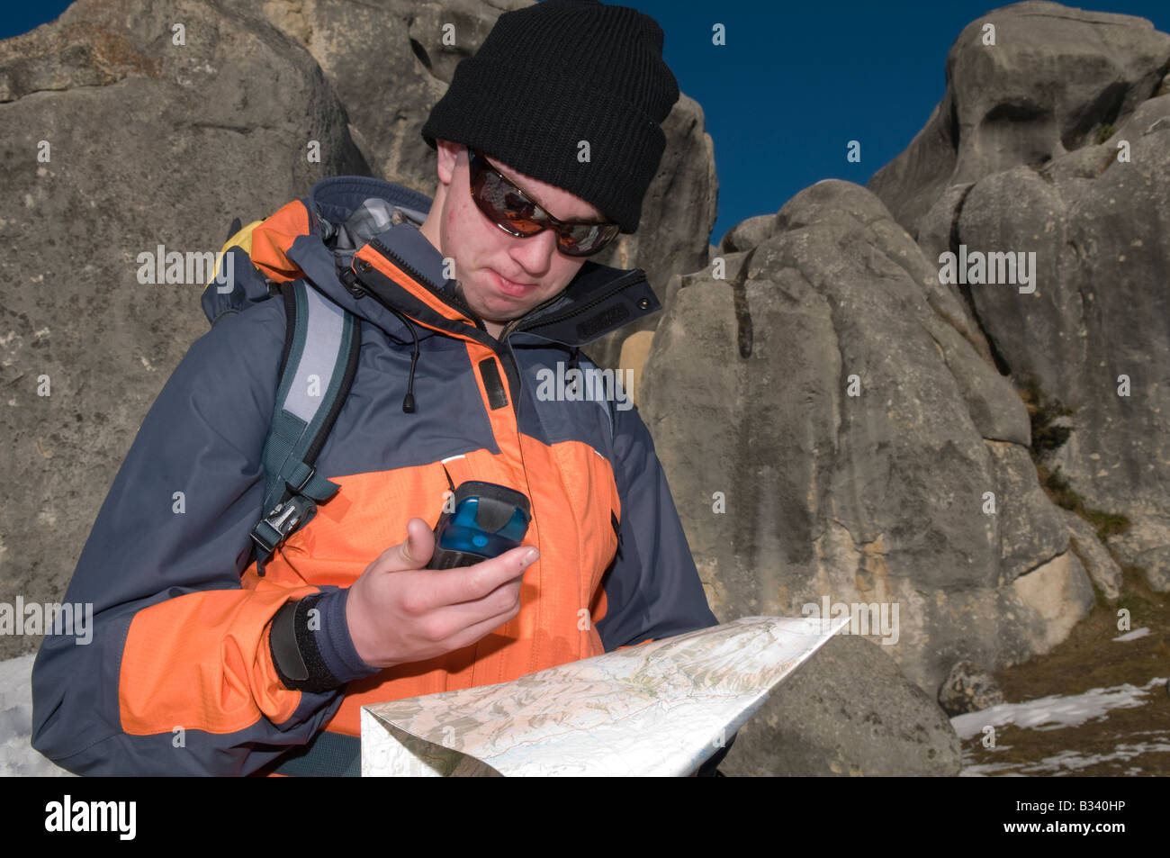 Winter hiker checks map against GPS Stock Photo - Alamy