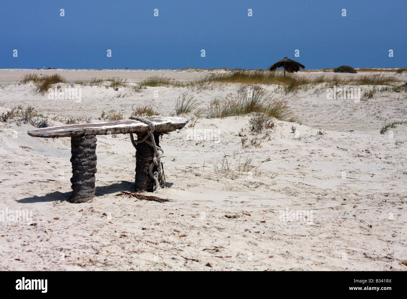 Lonely bench on the sand beach Stock Photo - Alamy