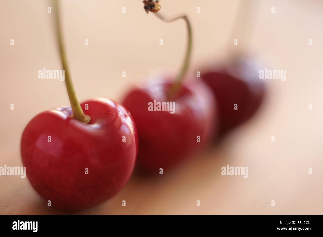 three cherries in a line Stock Photo - Alamy