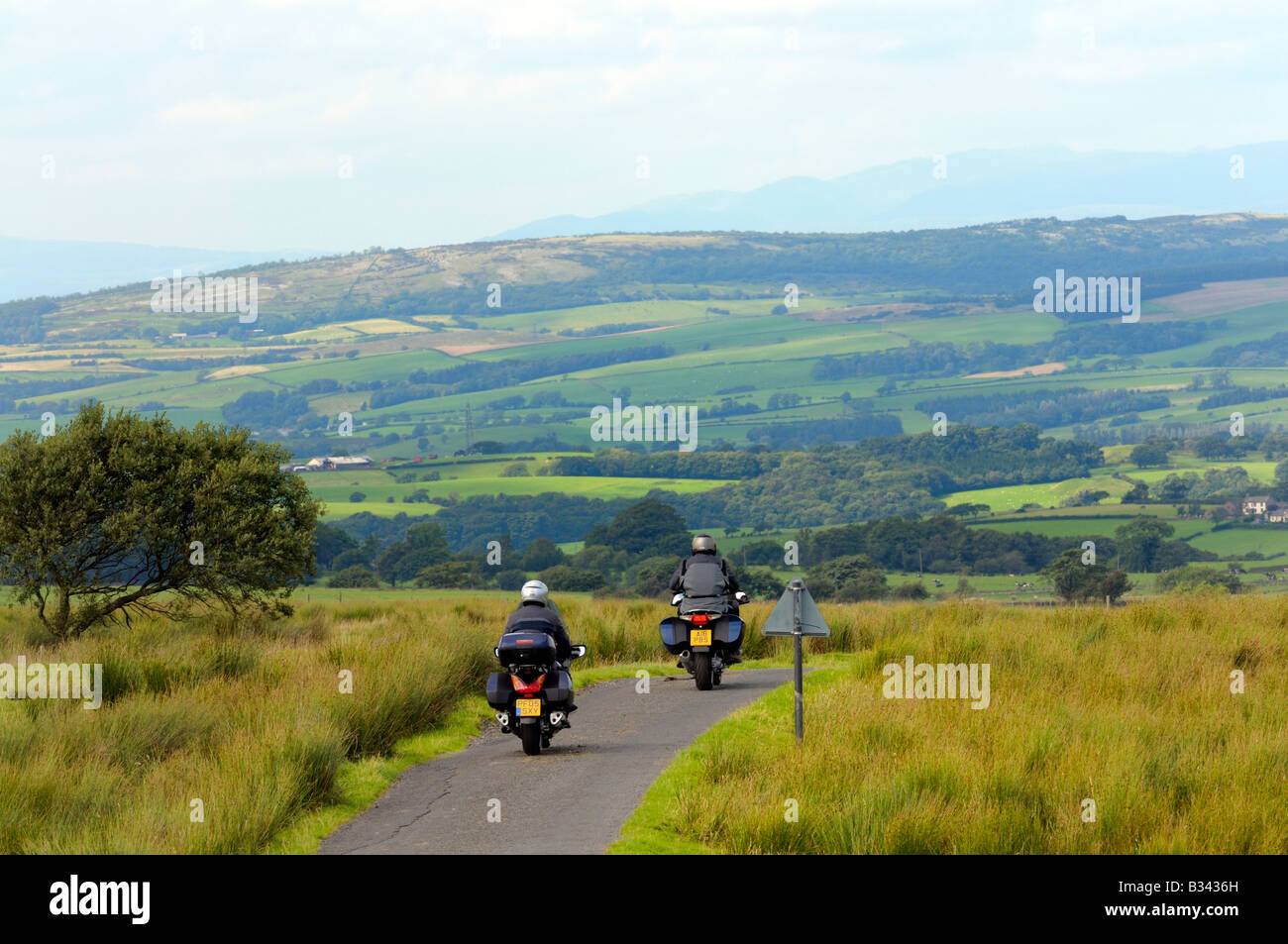 Two motorcycles on a single track country lane heading into the ...