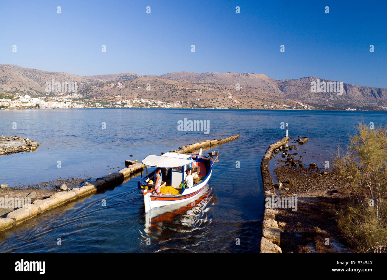 fishing boat sailing through canal causeway leading to kolokitha ...