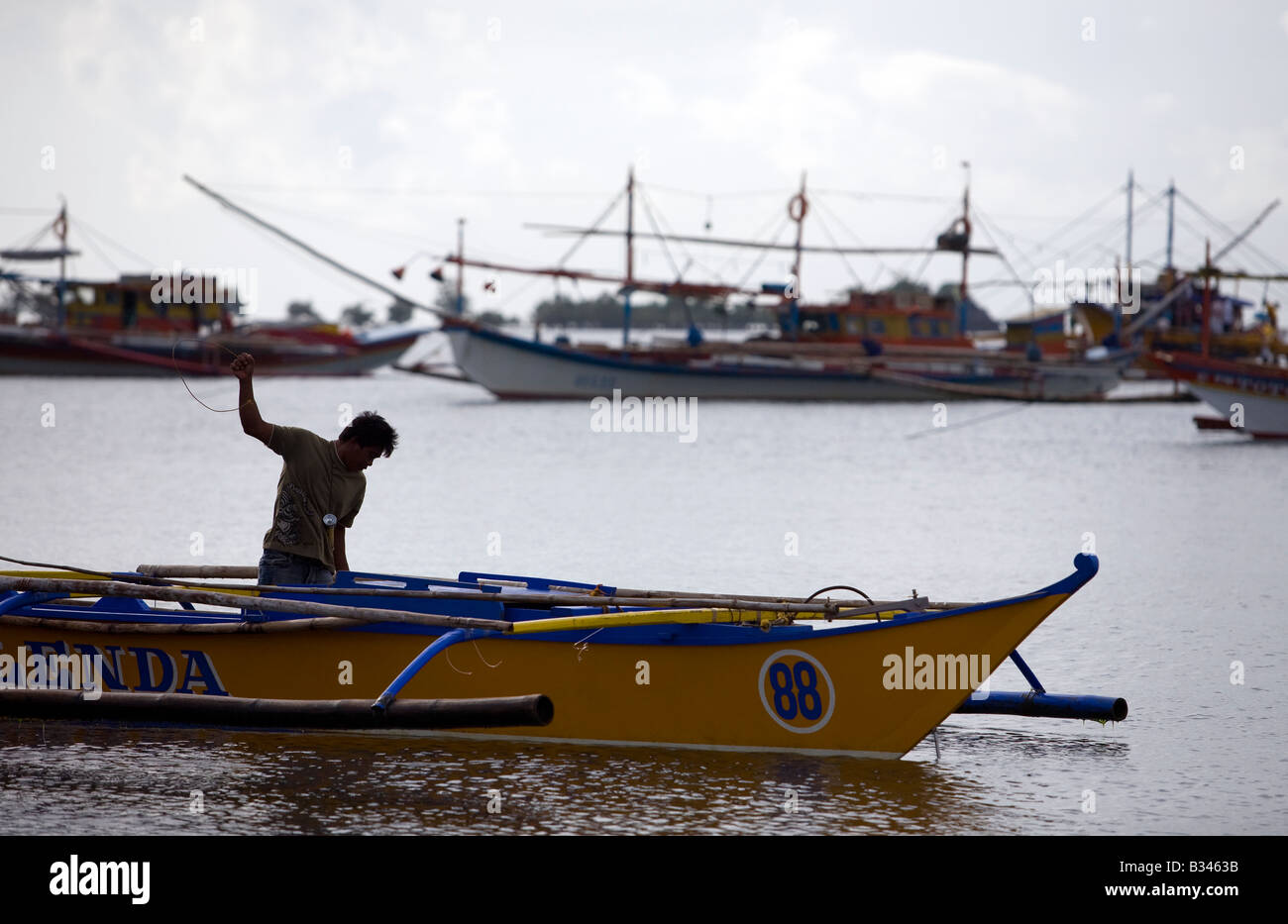 A Filipino starts his bangka boat in Mansalay Bay, Oriental Mindoro ...