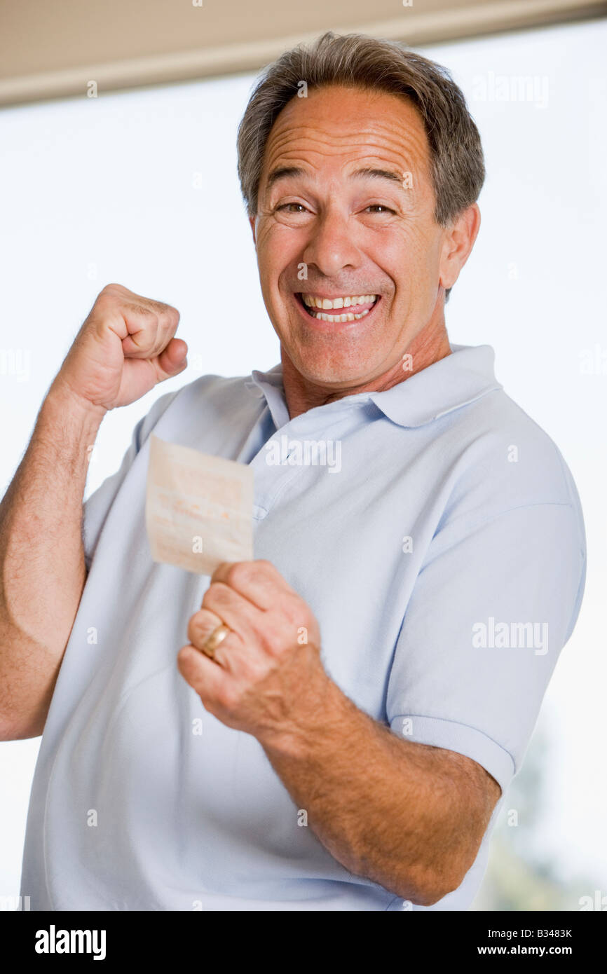 Man with winning lottery ticket excited and smiling hi-res stock ...