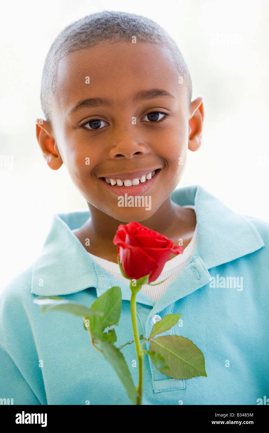 Young boy holding rose smiling Stock Photo - Alamy