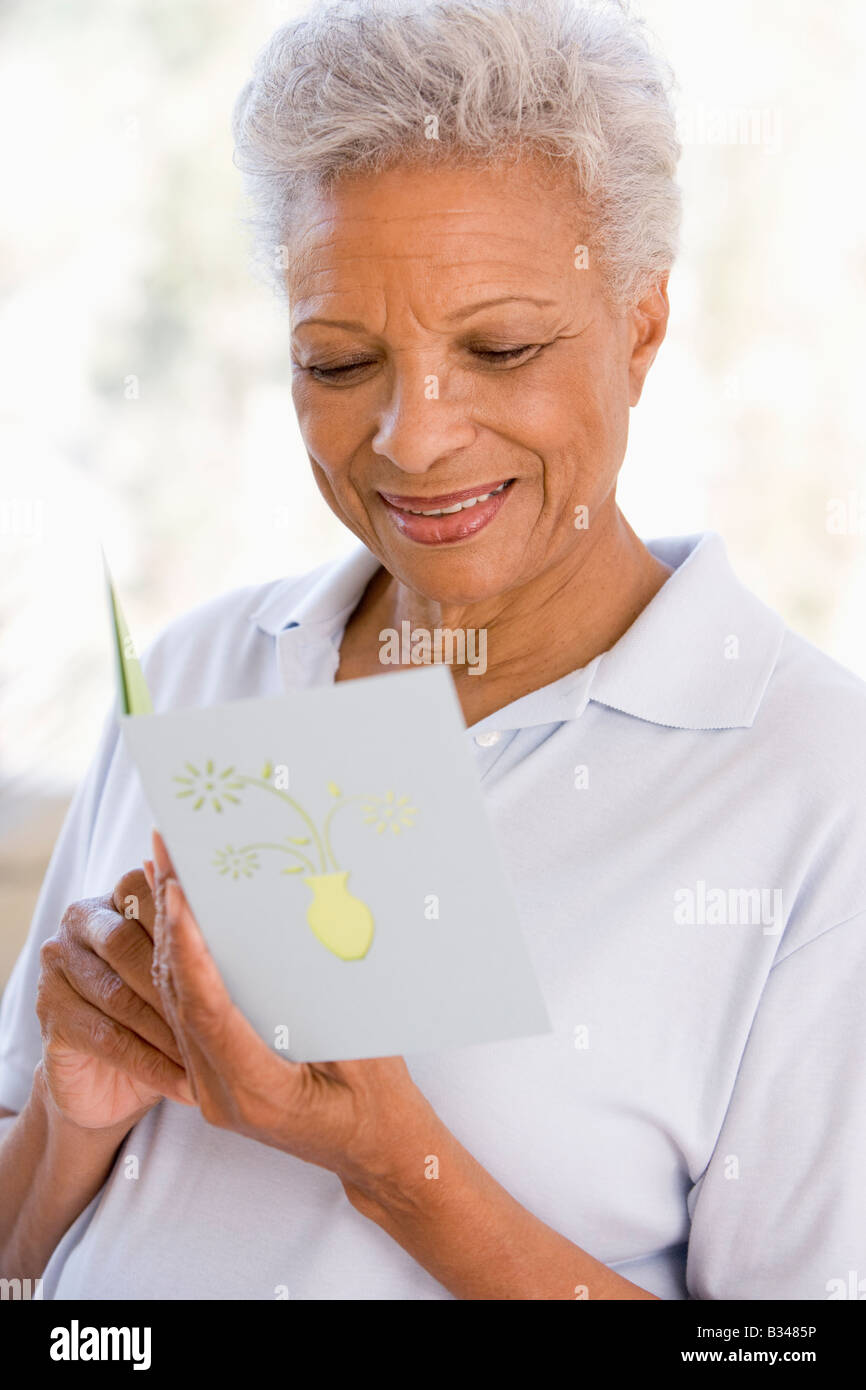 Woman reading card and smiling Stock Photo - Alamy