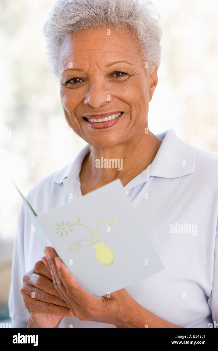 Woman reading card and smiling Stock Photo - Alamy