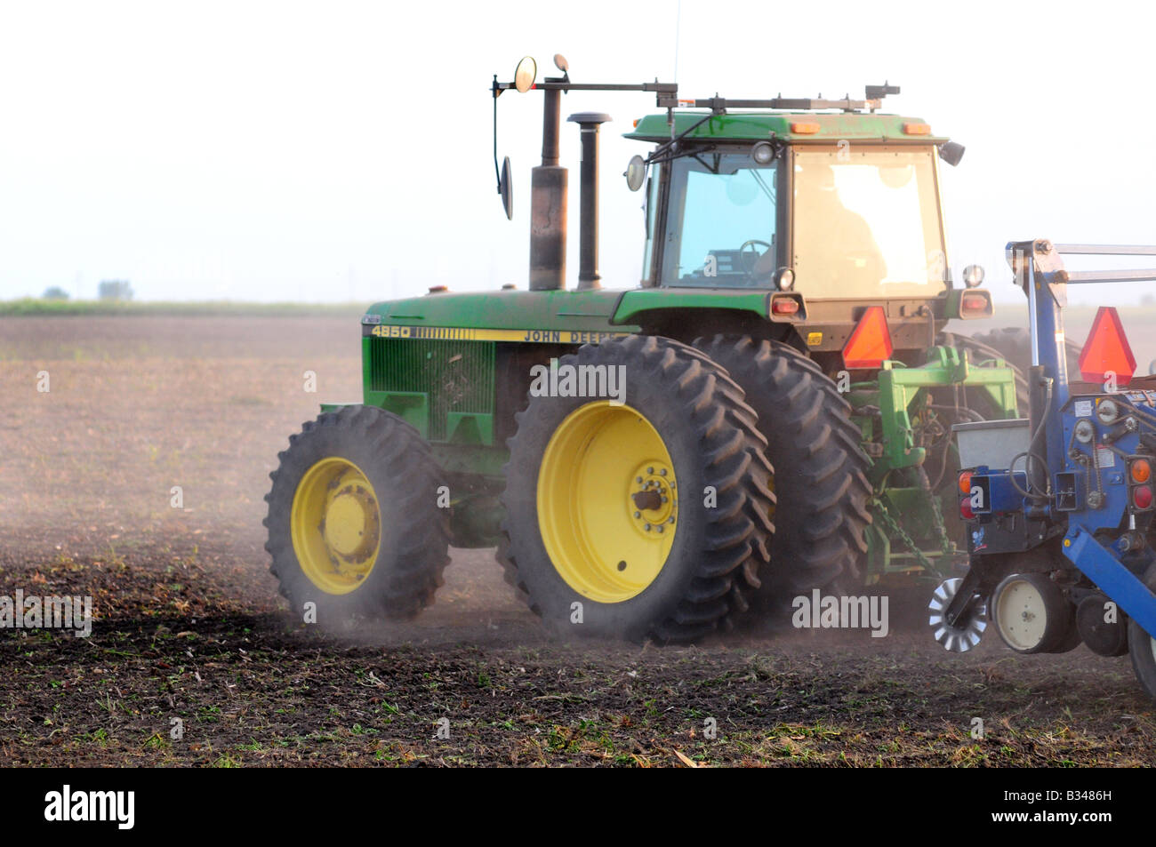 John Deere tractor planting corn or soybeans in an American farm field ...