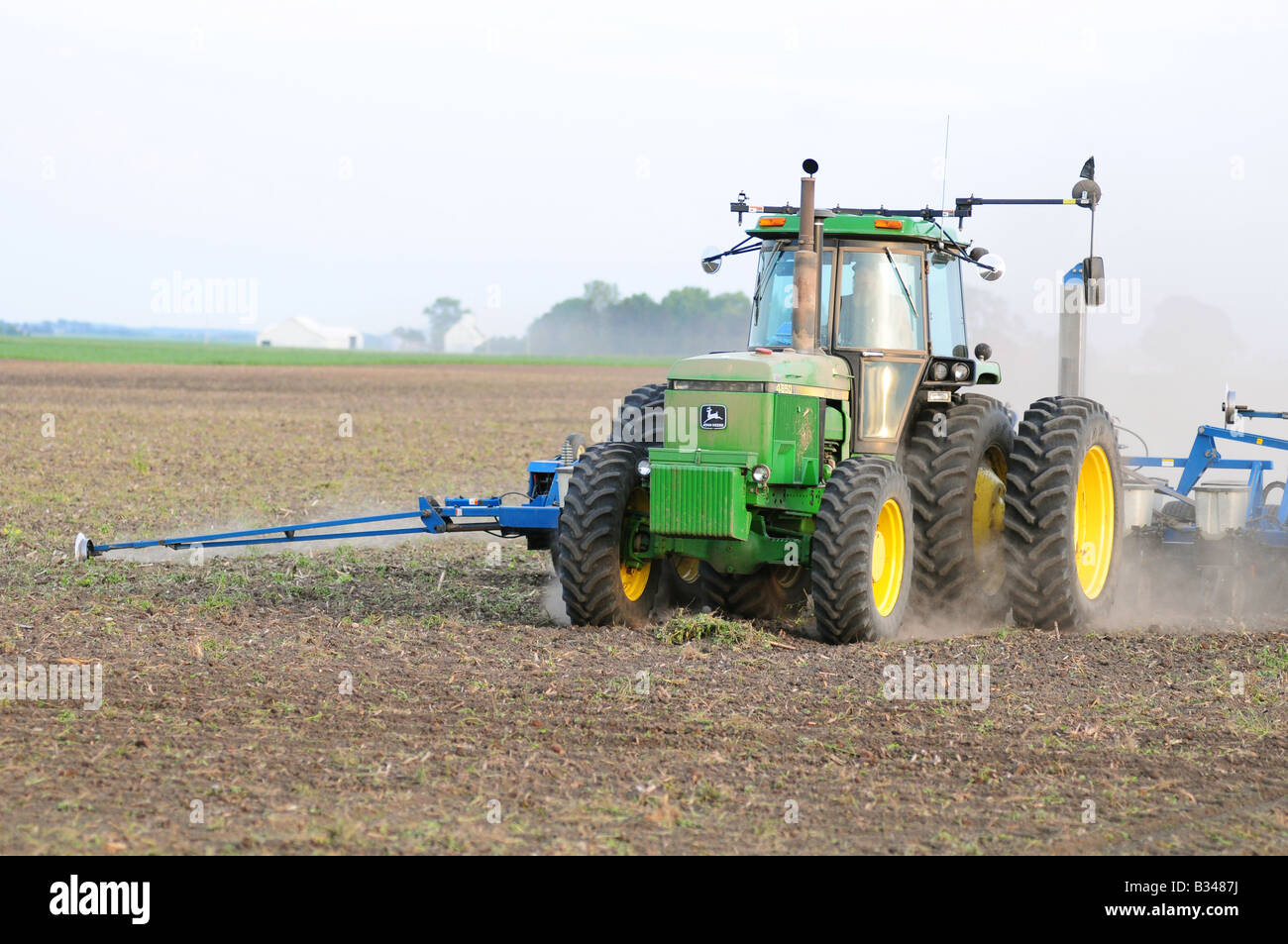 John Deere tractor planting corn or soybeans in an American farm field ...