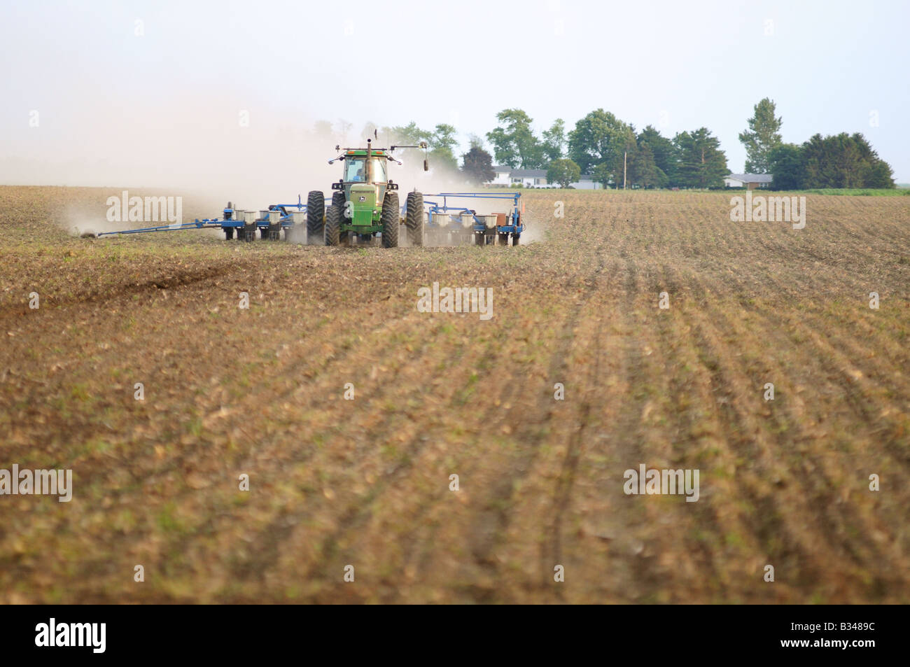 John Deere tractor planting corn or soybeans in an American farm field ...