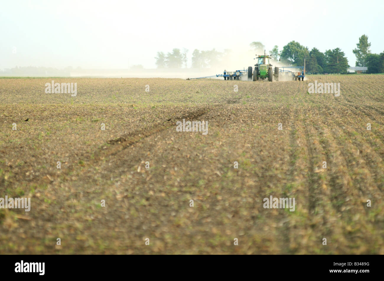 John Deere tractor planting corn or soybeans in an American farm field ...