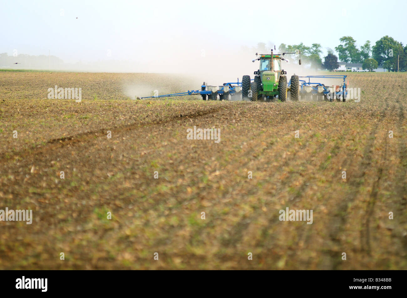John Deere tractor planting corn or soybeans in an American farm field ...