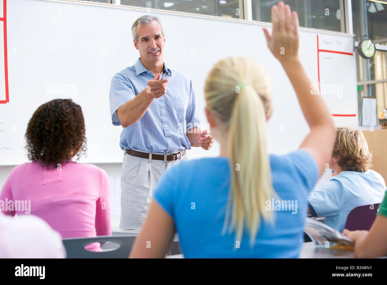 Students answering questions in math class with teacher Stock Photo - Alamy