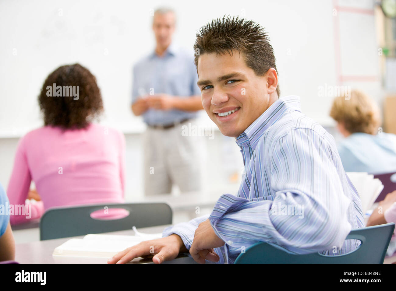 Male student with other students in classroom Stock Photo - Alamy