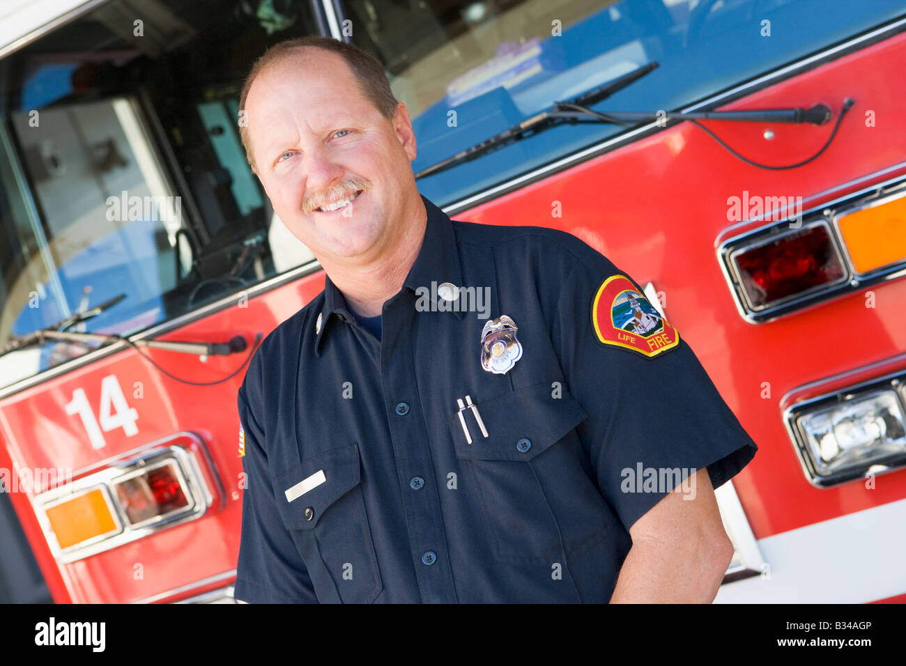 Fireman standing in front of fire engine Stock Photo - Alamy
