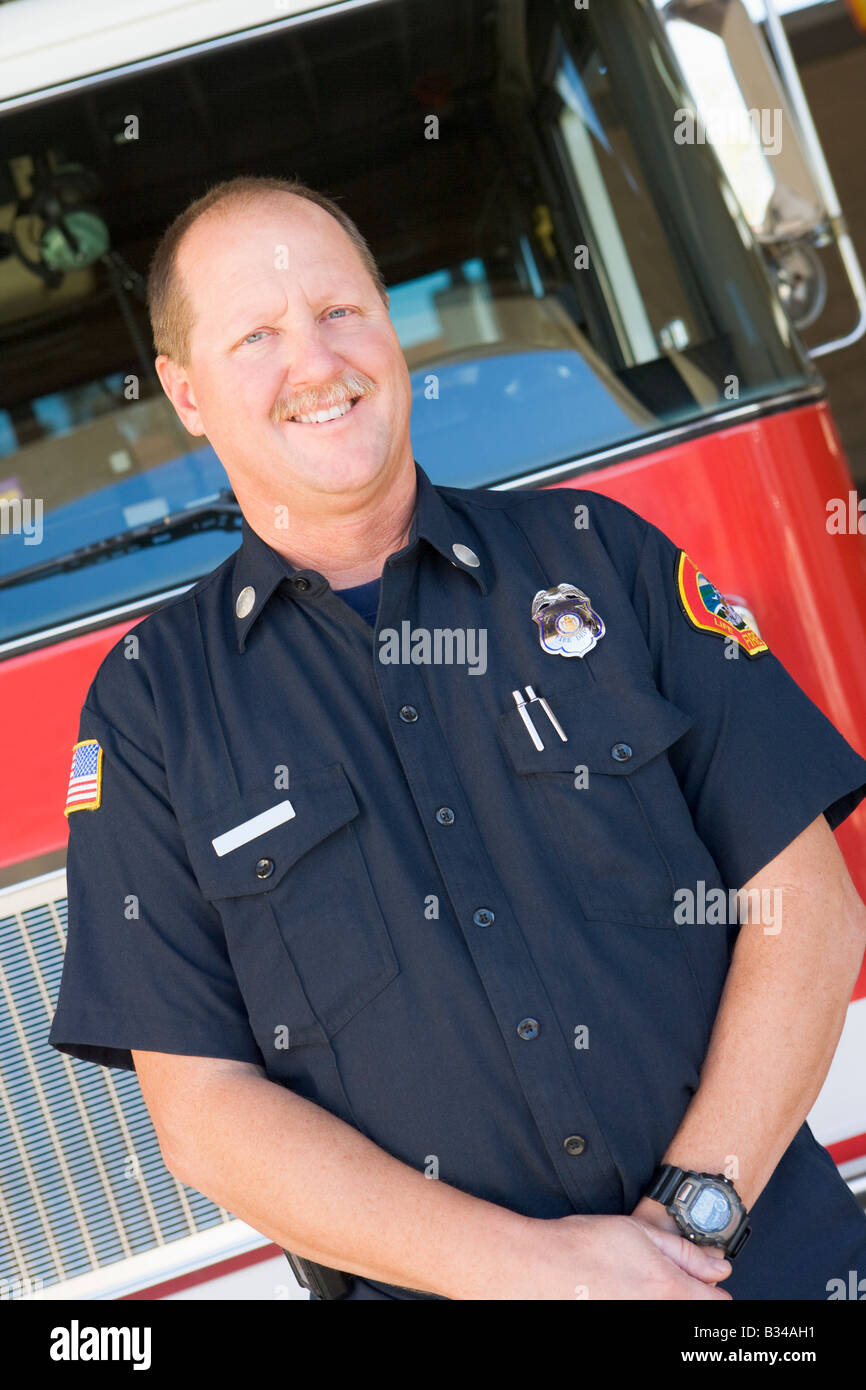 Fireman standing in front of fire engine Stock Photo - Alamy