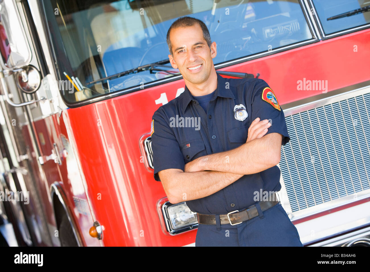 Fireman standing in front of fire engine Stock Photo - Alamy