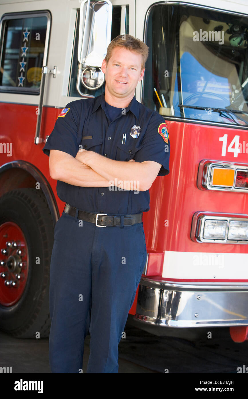 Fireman standing in front of fire engine Stock Photo - Alamy