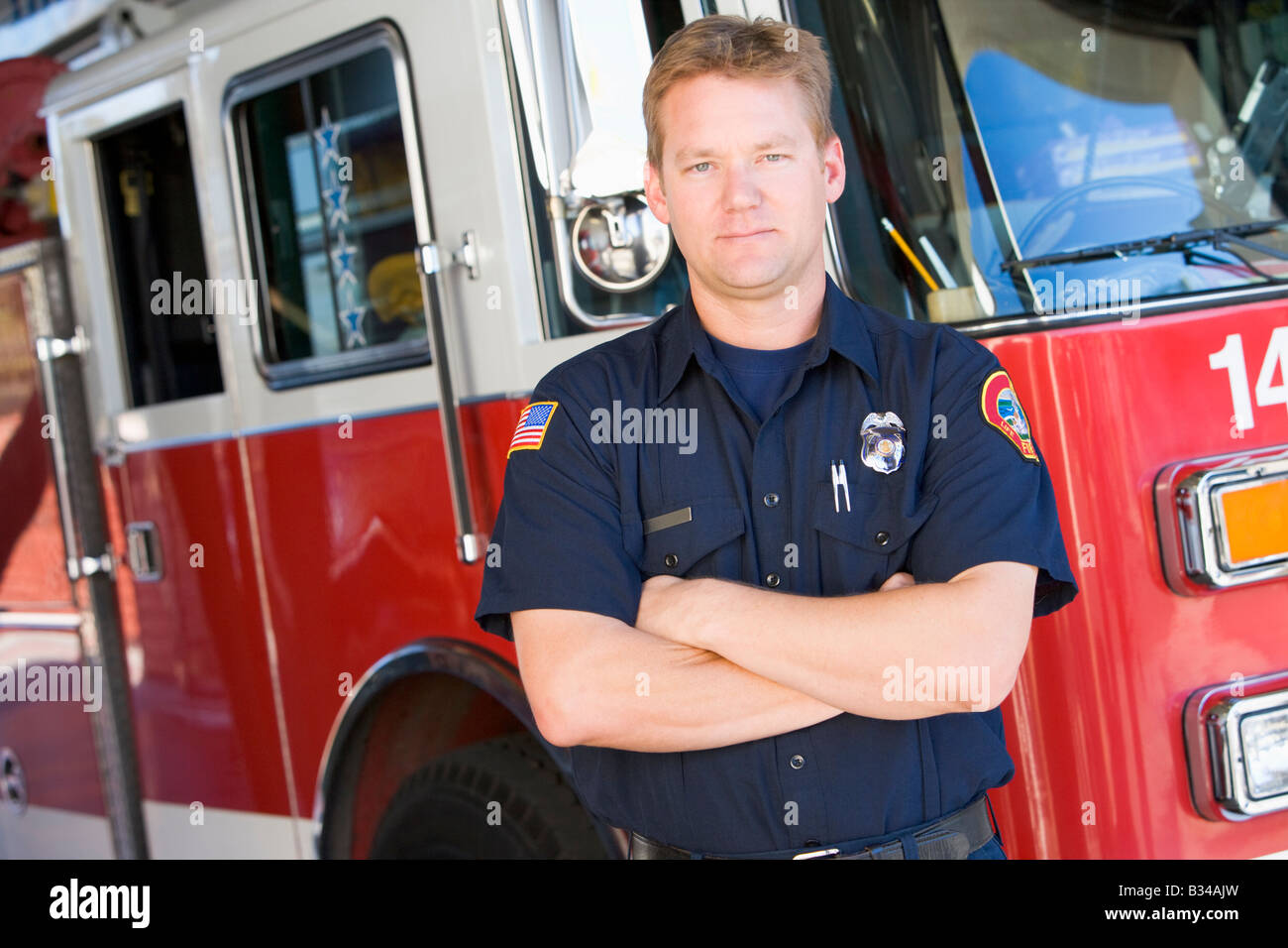Fireman standing in front of fire engine Stock Photo - Alamy