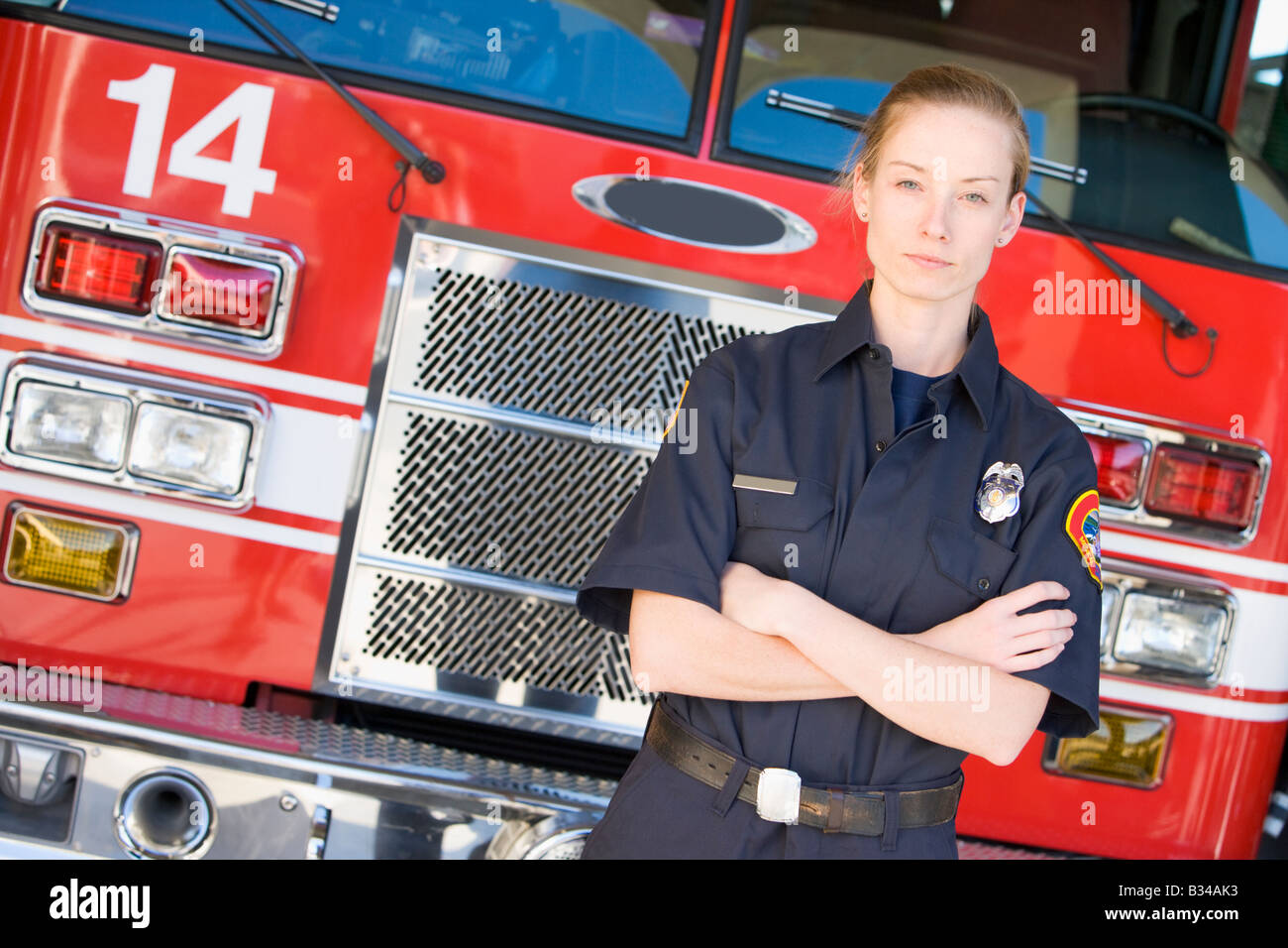Firewoman standing in front of fire engine Stock Photo - Alamy