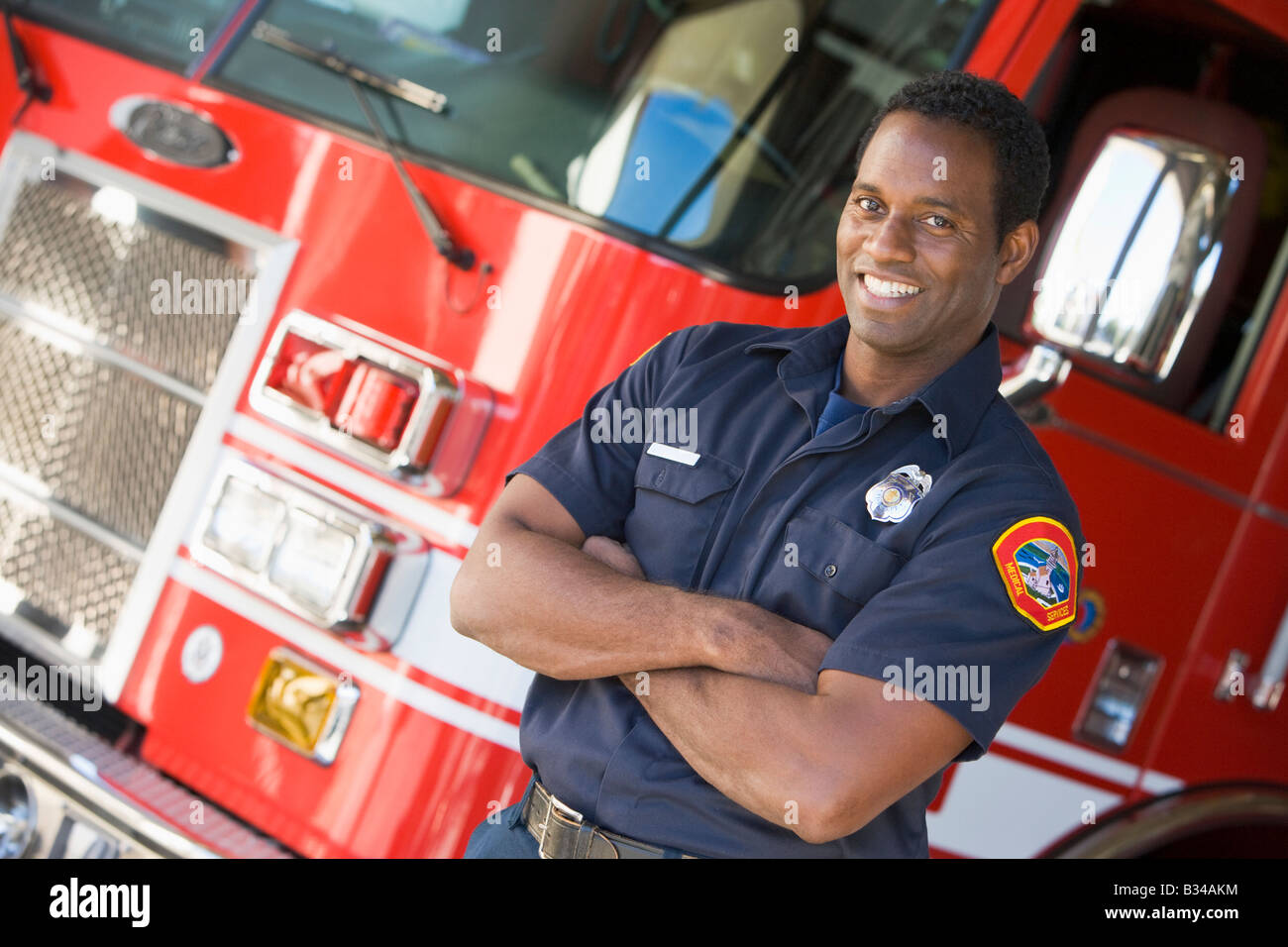 Fireman standing in front of fire engine Stock Photo - Alamy