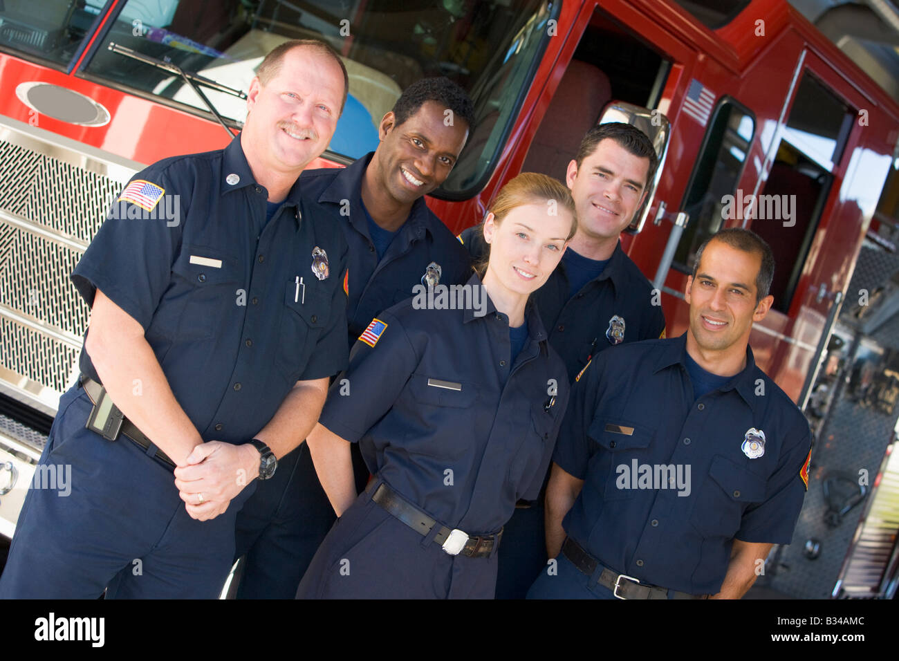Five firefighters standing in front of fire engine Stock Photo - Alamy