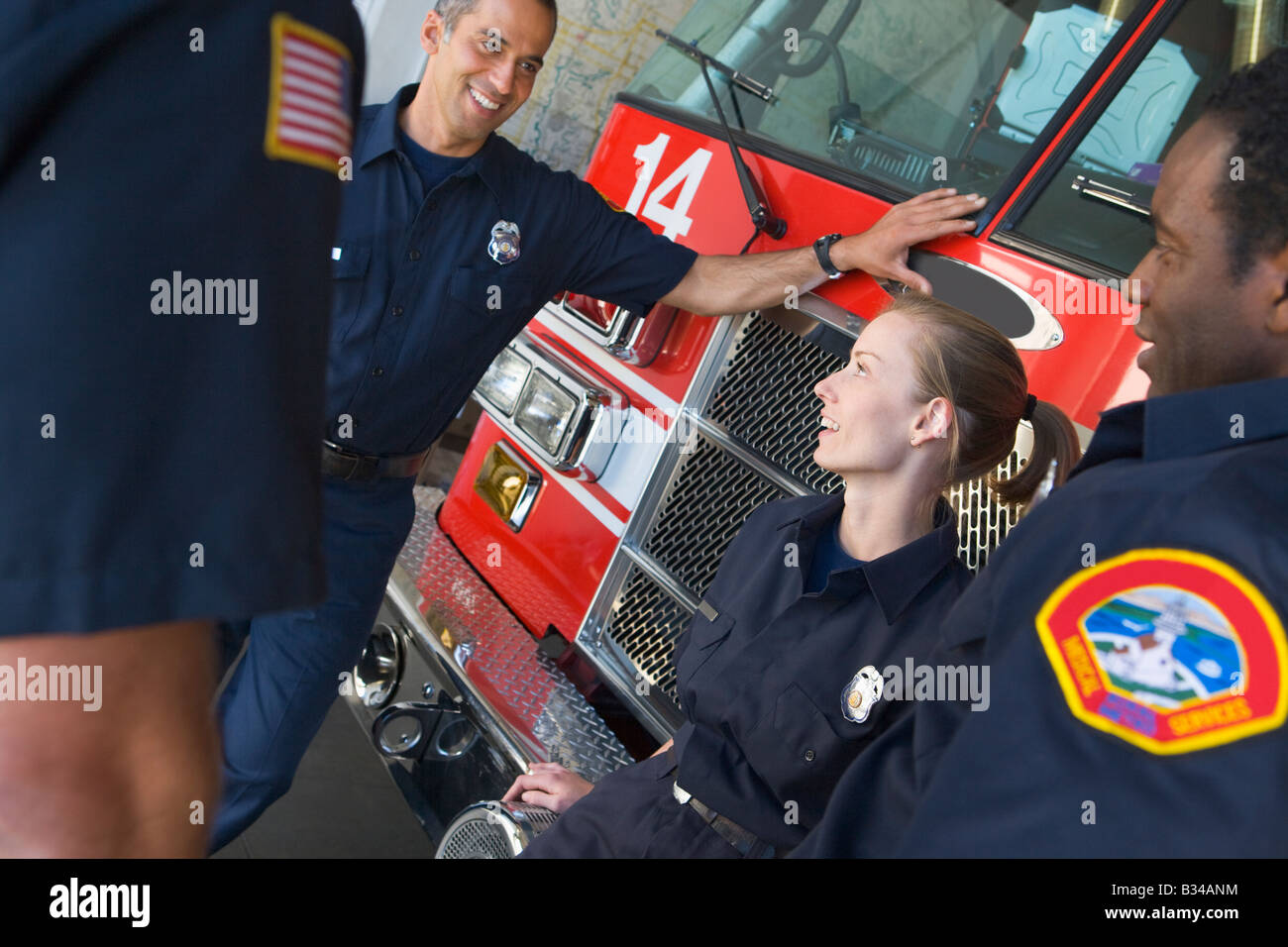 Four firefighters talking by fire engine Stock Photo - Alamy