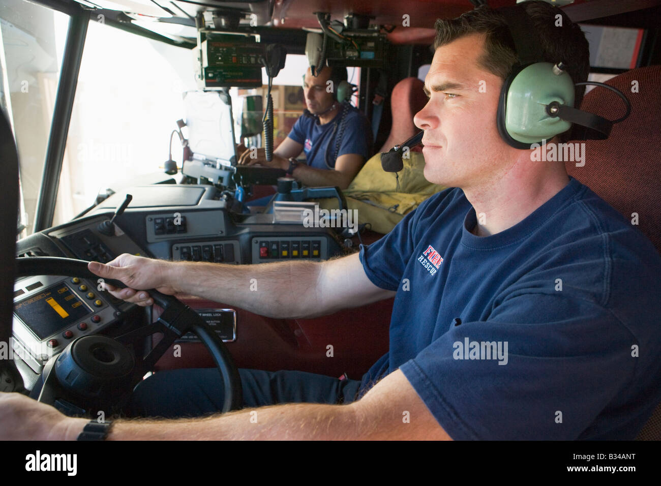 Two firemen in fire engine Stock Photo - Alamy
