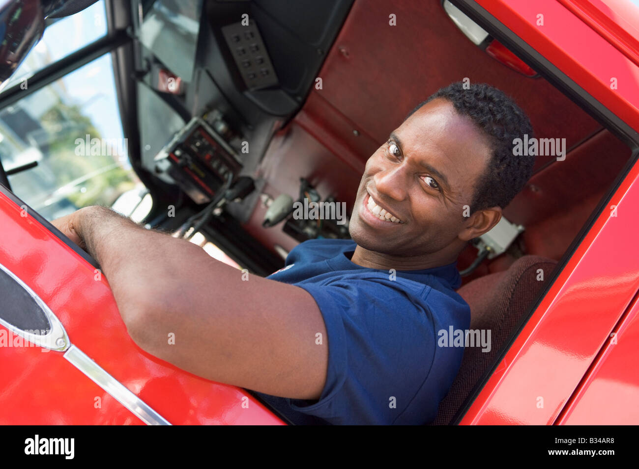 Fireman in driver's seat of fire engine Stock Photo - Alamy