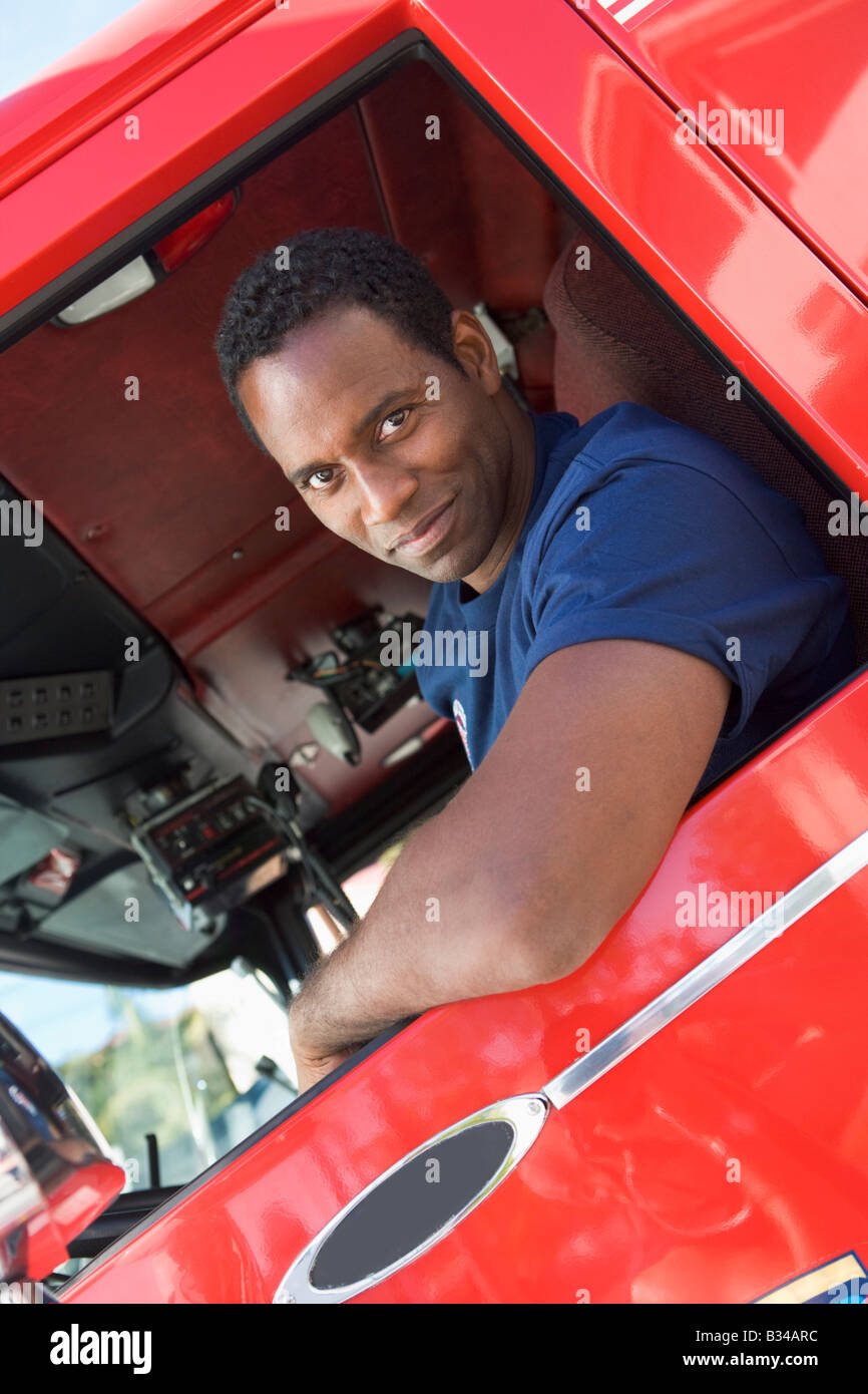 Fireman in driver's seat of fire engine Stock Photo - Alamy