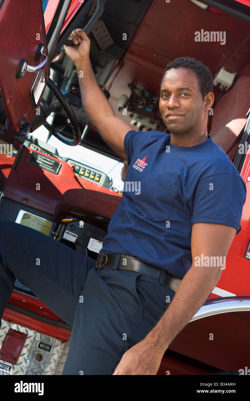 Fireman leaning in door of fire engine Stock Photo - Alamy