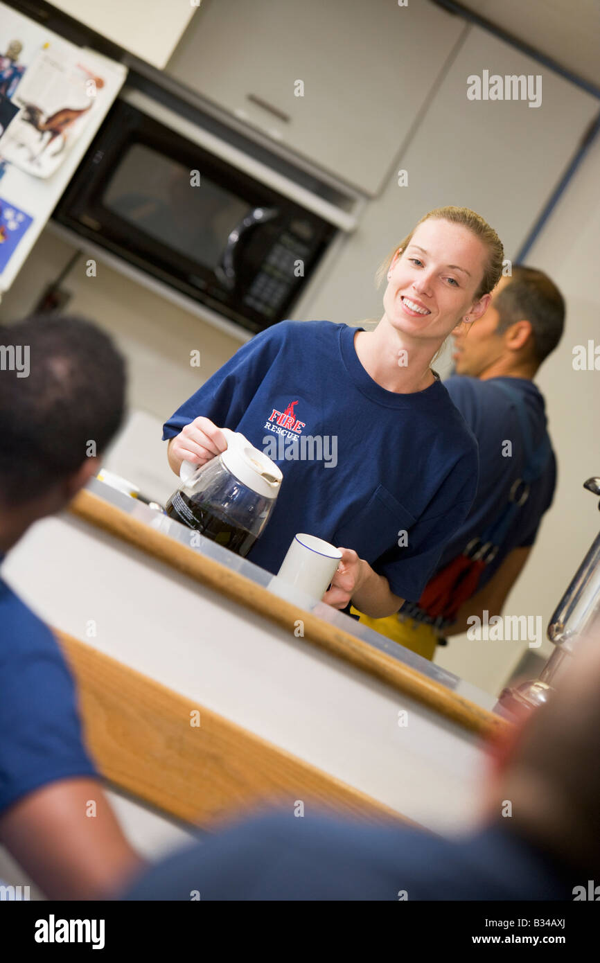 Four firefighters in break room with one getting coffee (selective ...