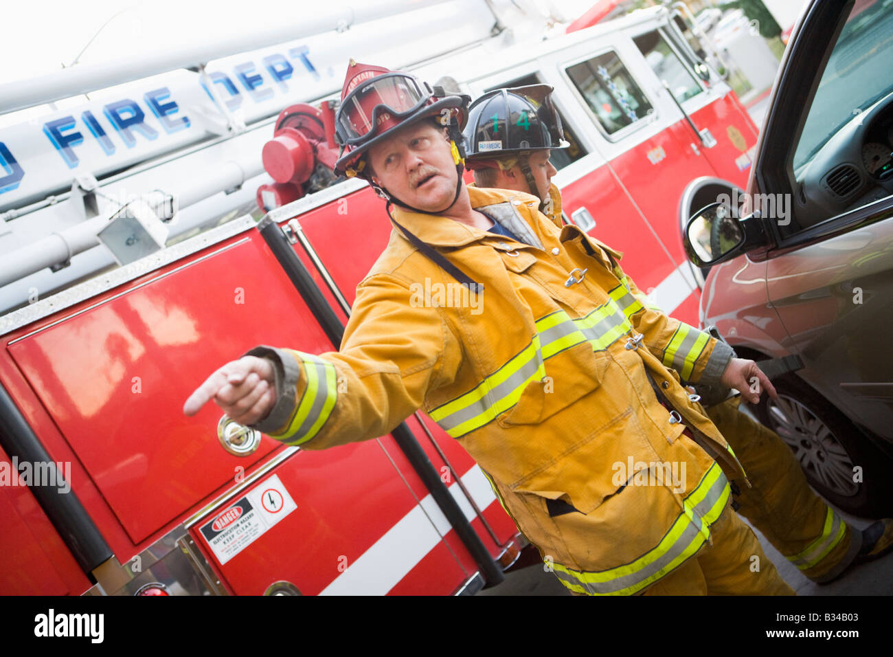 Fireman pointing at something with another fireman using the jaws of ...