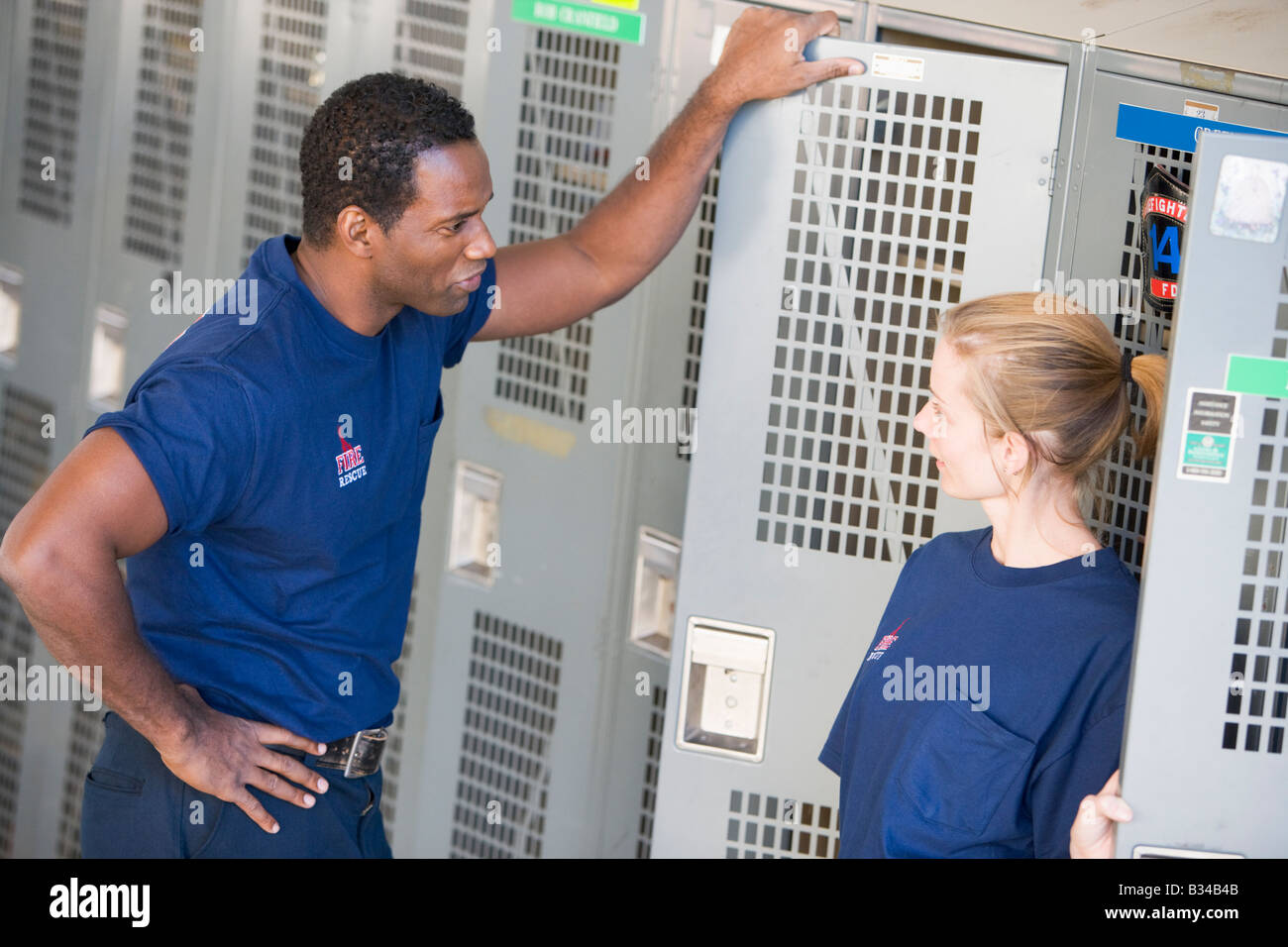 Two firefighters in locker room talking (depth of field Stock Photo - Alamy