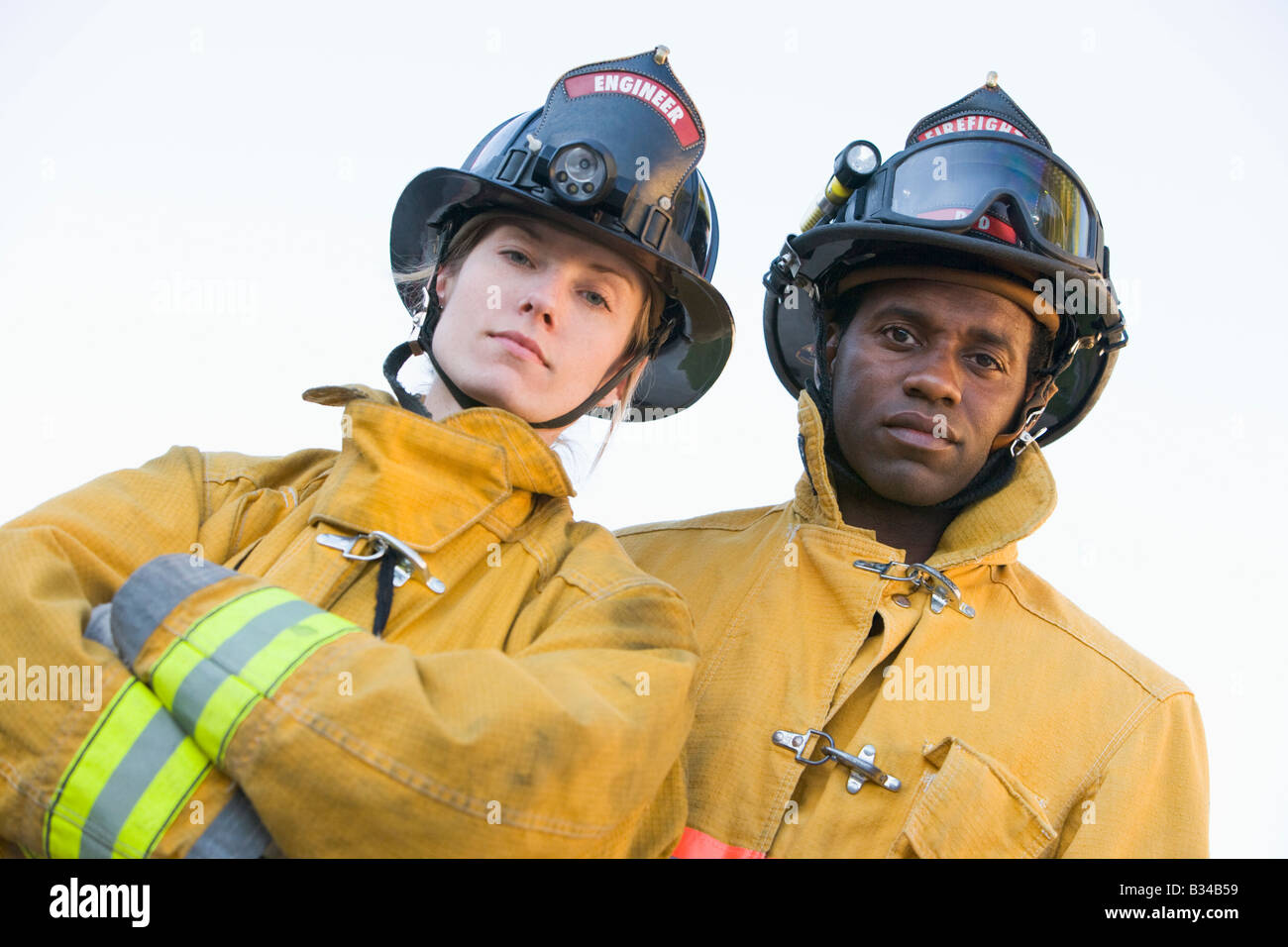 Two firefighters standing outdoors wearing helmets Stock Photo - Alamy