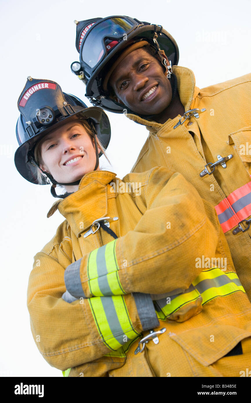 Two firefighters standing outdoors wearing helmets Stock Photo - Alamy