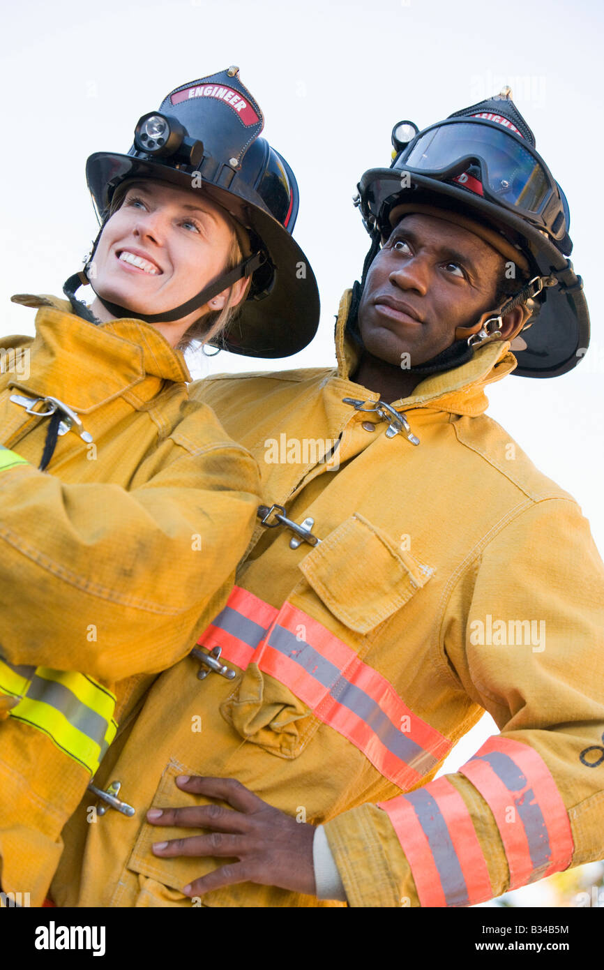 Two firefighters standing outdoors wearing helmets Stock Photo - Alamy