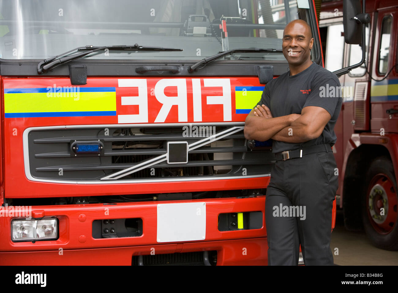 Fireman standing in front of fire engine Stock Photo - Alamy