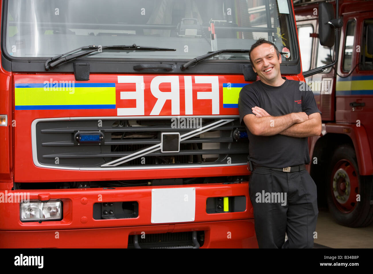 Fireman standing in front of fire engine Stock Photo - Alamy