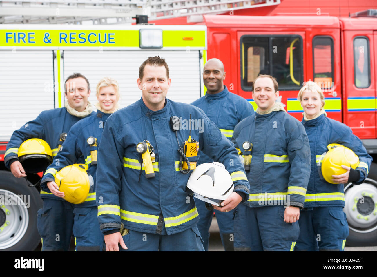 Six firefighters standing by fire engine Stock Photo - Alamy