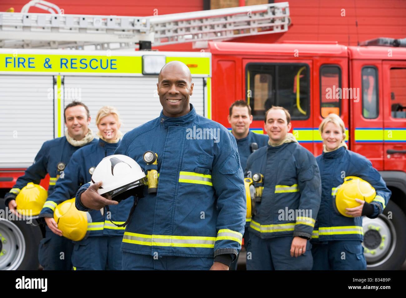 Six firefighters standing by fire engine Stock Photo - Alamy