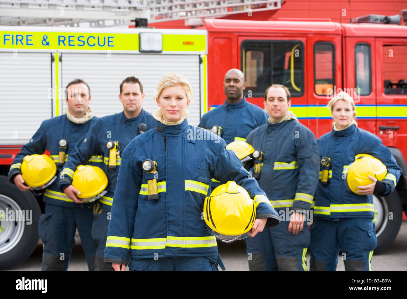 Six firefighters standing by fire engine Stock Photo - Alamy