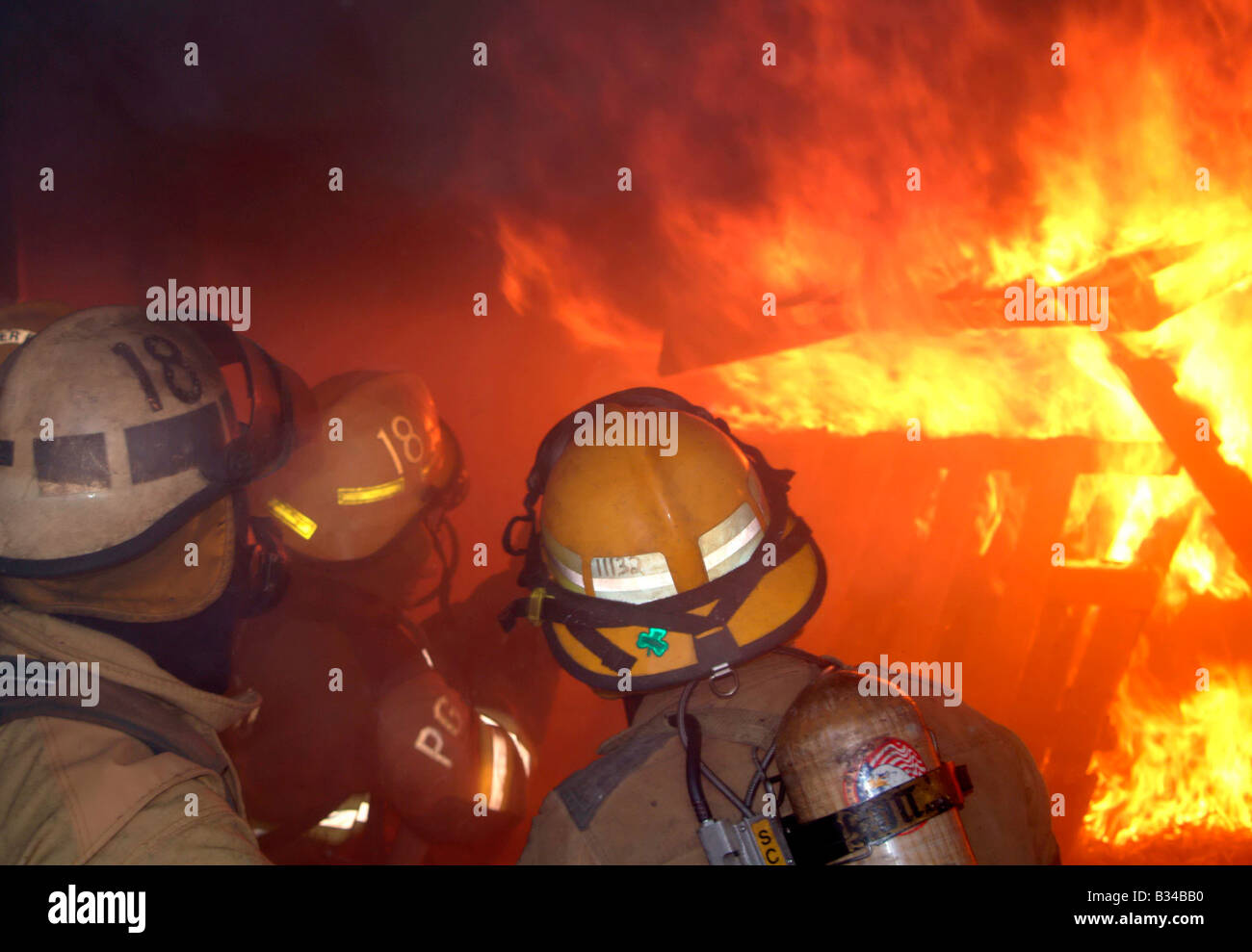 Firefighters fighting flames inside a house Stock Photo - Alamy