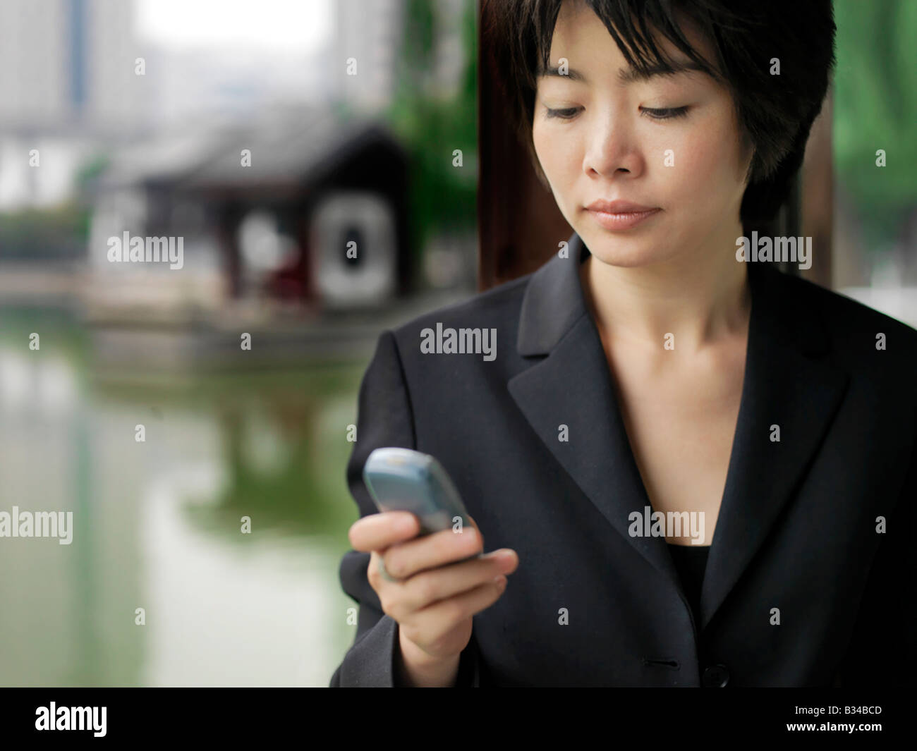 A Chinese businesswoman using her mobile phone with Chinese ...