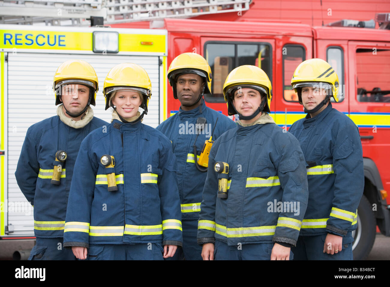 Five firefighters standing by fire engine wearing helmets Stock Photo ...