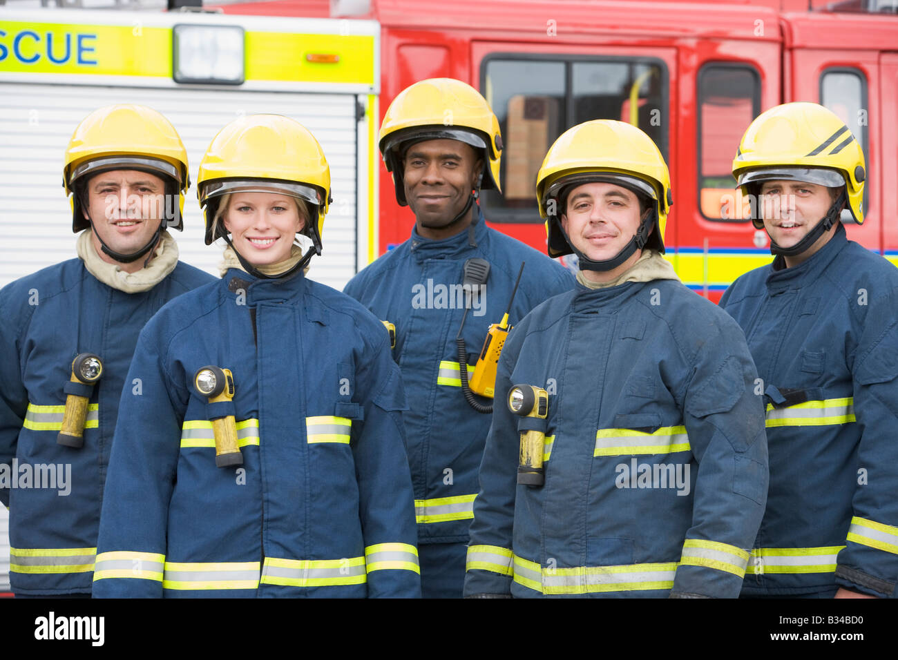 Five firefighters standing by fire engine wearing helmets Stock Photo ...