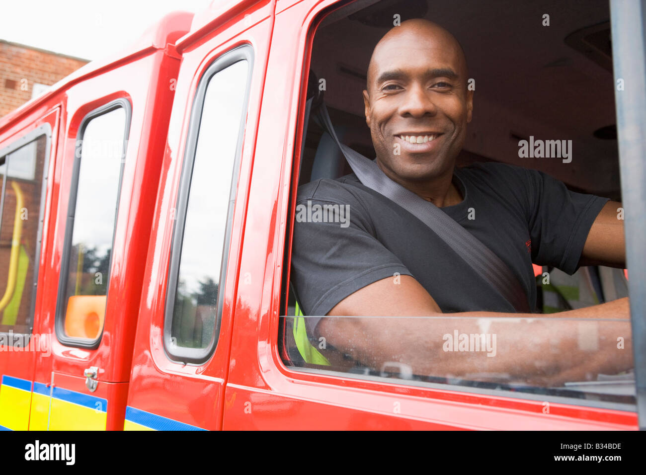 Fireman sitting in fire engine looking out window Stock Photo - Alamy