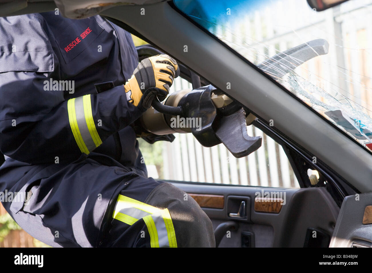 Firefighter cutting out a windshield after an accident Stock Photo - Alamy
