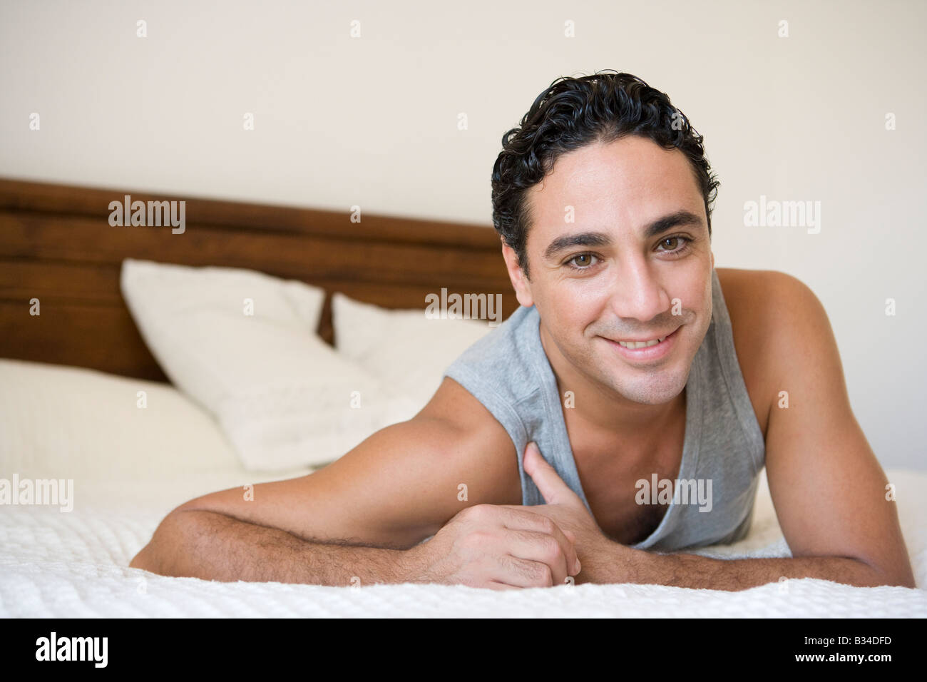 Man relaxing on bed in bedroom smiling (selective focus Stock Photo - Alamy